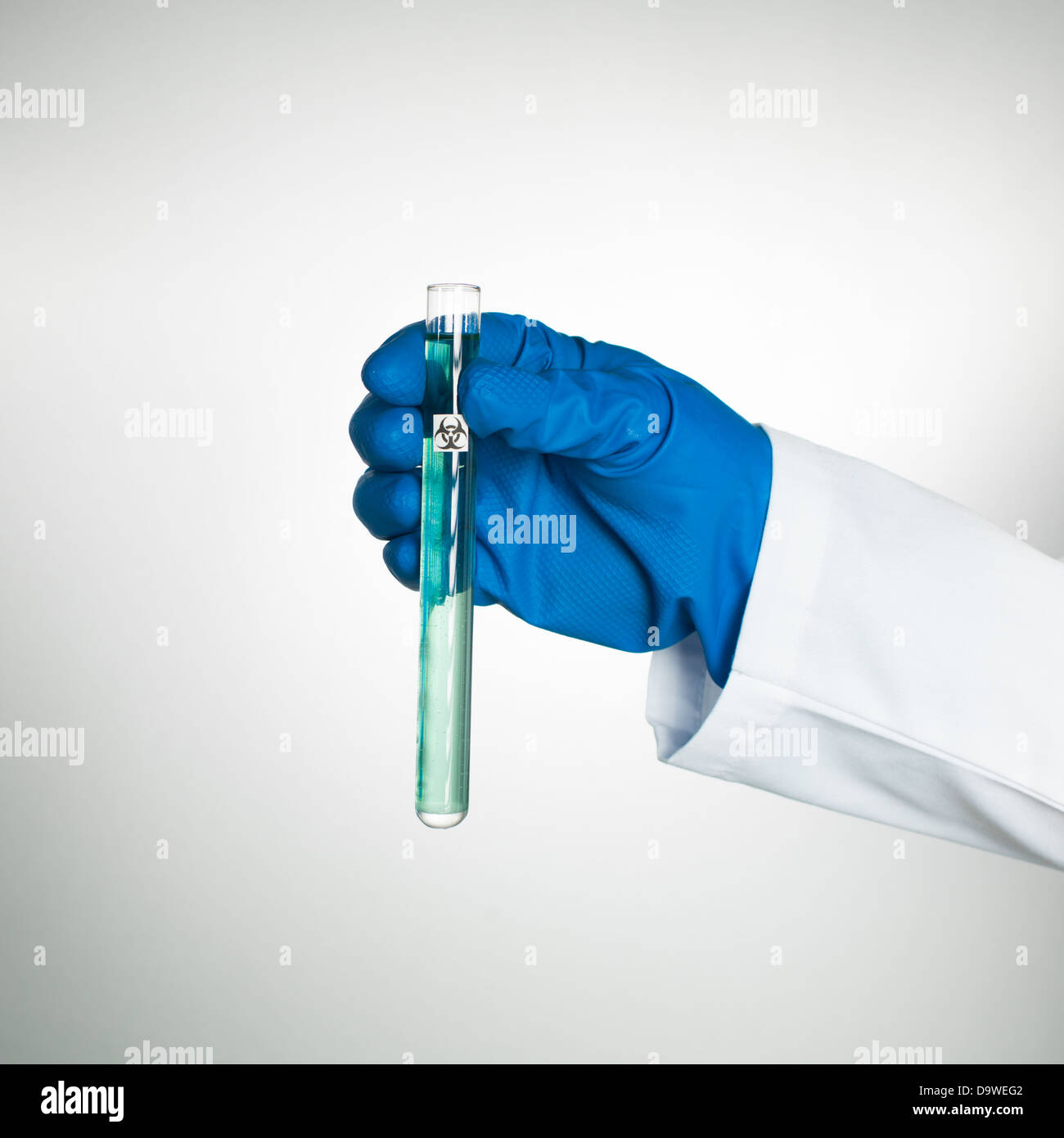 test tube labeled as bio hazardous containing a transparent green ...