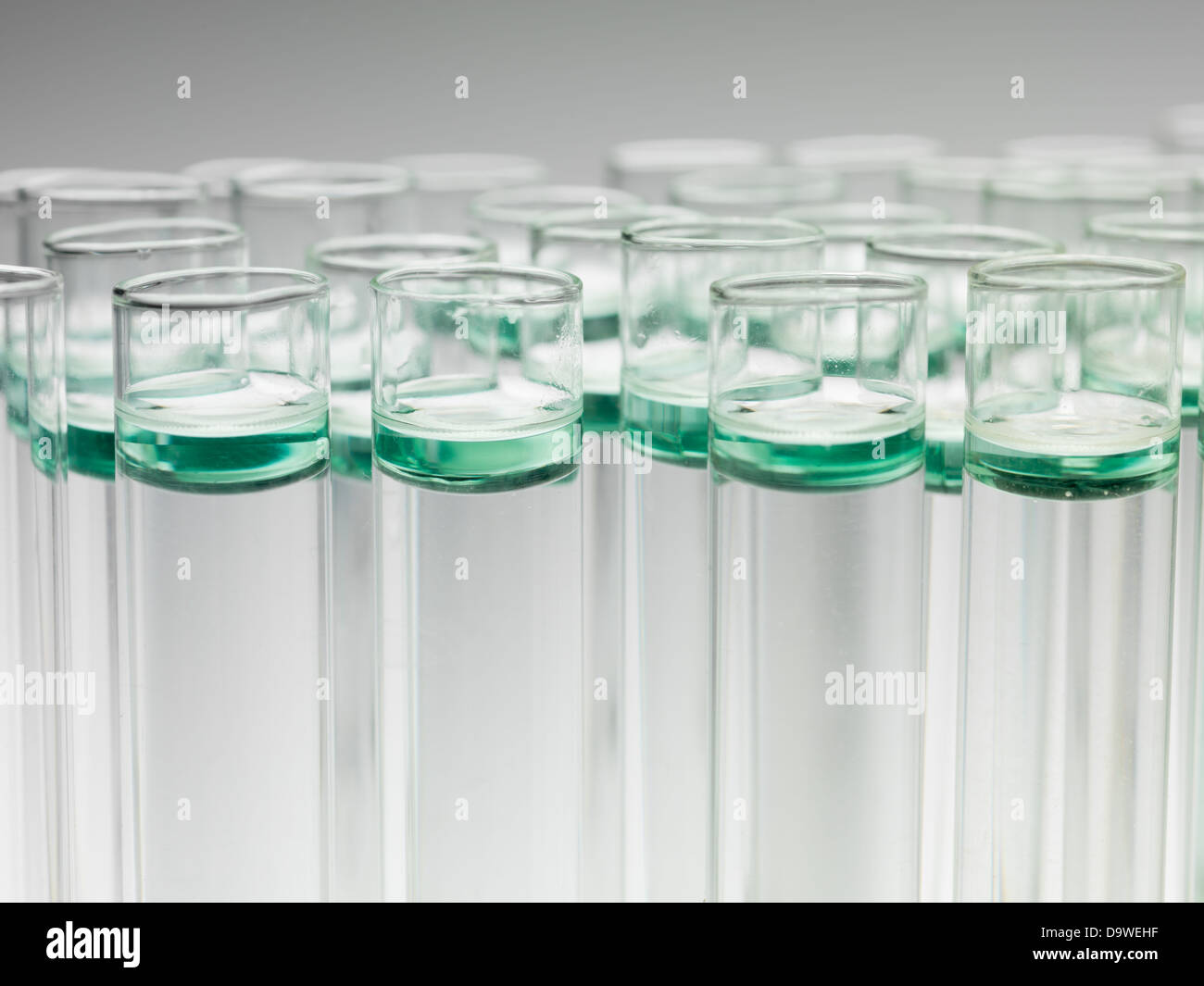 side view, macro of test tubes filled with transparent green floating ...