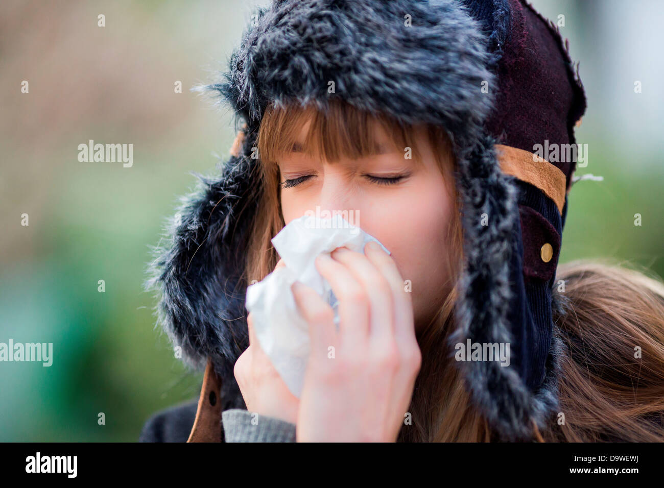 Woman with a cold using tissue Stock Photo - Alamy