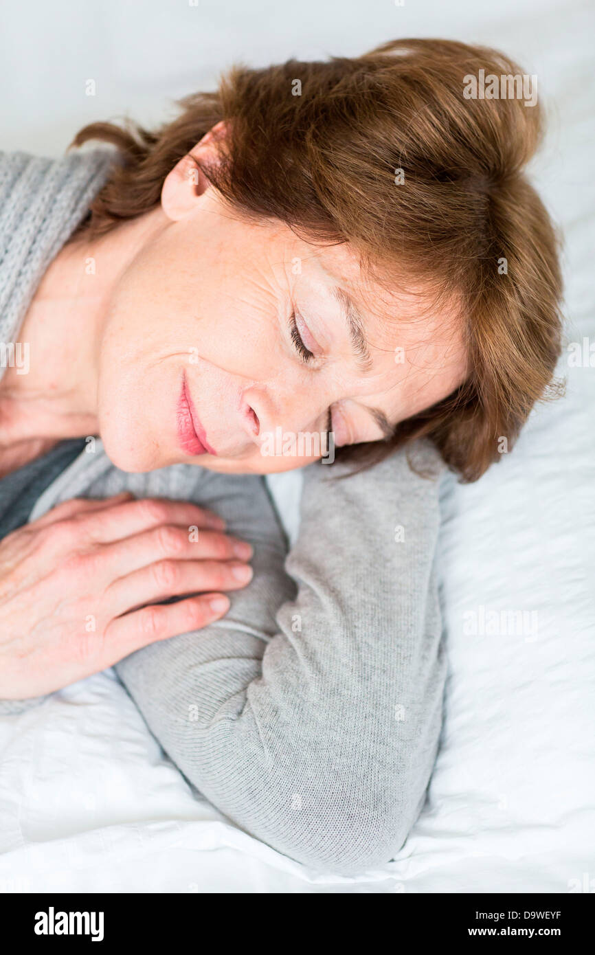 Senior woman napping on bed Stock Photo - Alamy