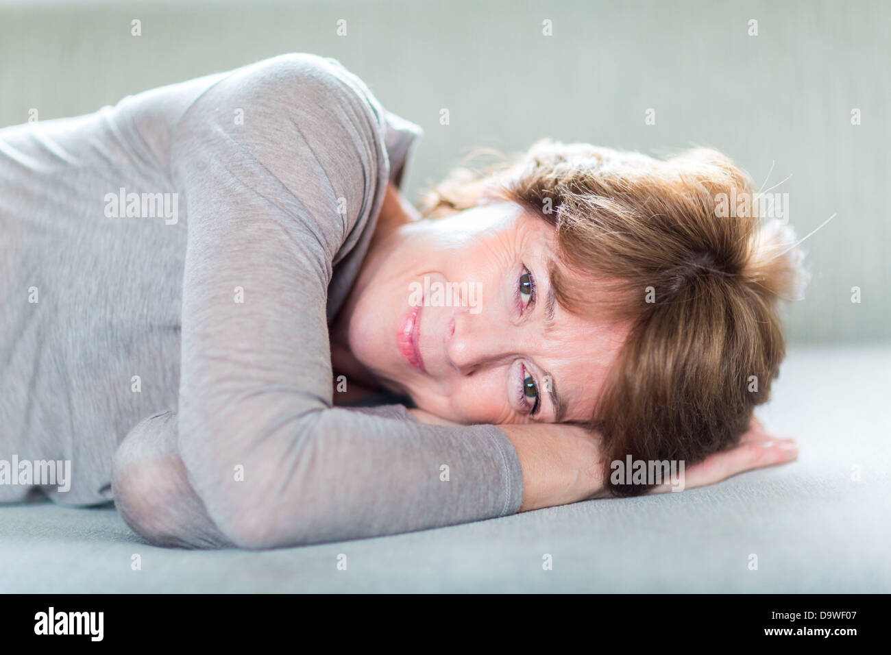 Senior woman napping on couch Stock Photo - Alamy
