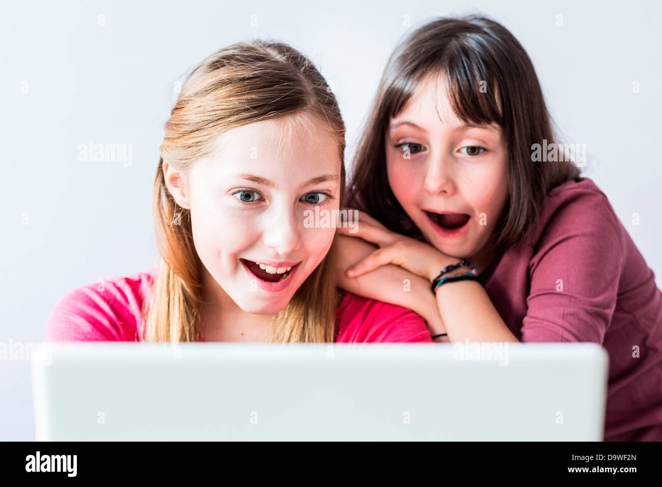 Sisters using laptop computer Stock Photo - Alamy