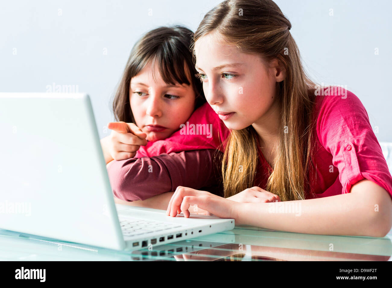 Sisters using laptop computer Stock Photo - Alamy