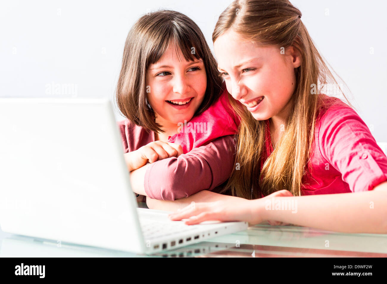Sisters using laptop computer Stock Photo - Alamy