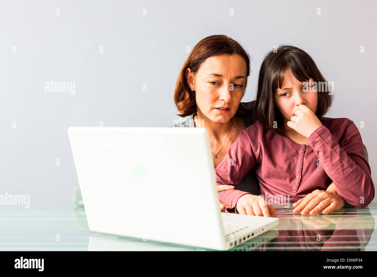 Mother and her 9-year-old daughter using laptop computer Stock Photo ...