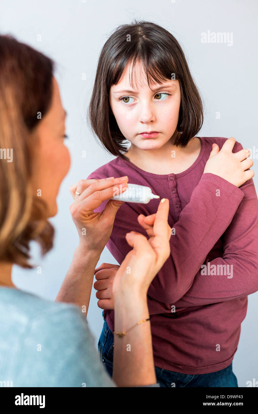 Mother applying pomade on her daughter Stock Photo - Alamy