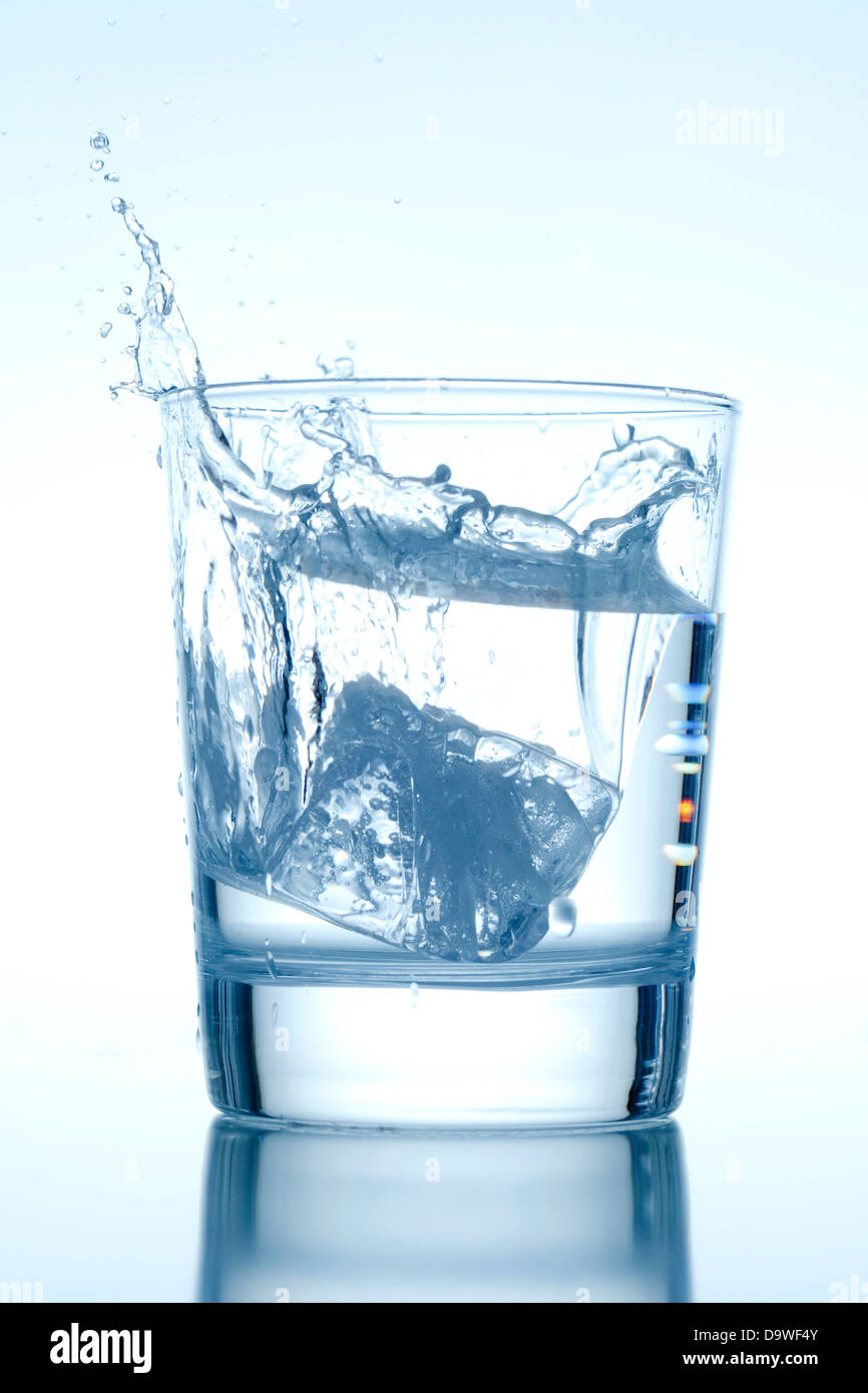 Ice Cube Falling into a Glass of Water Splashing Surface Stock Photo - Alamy