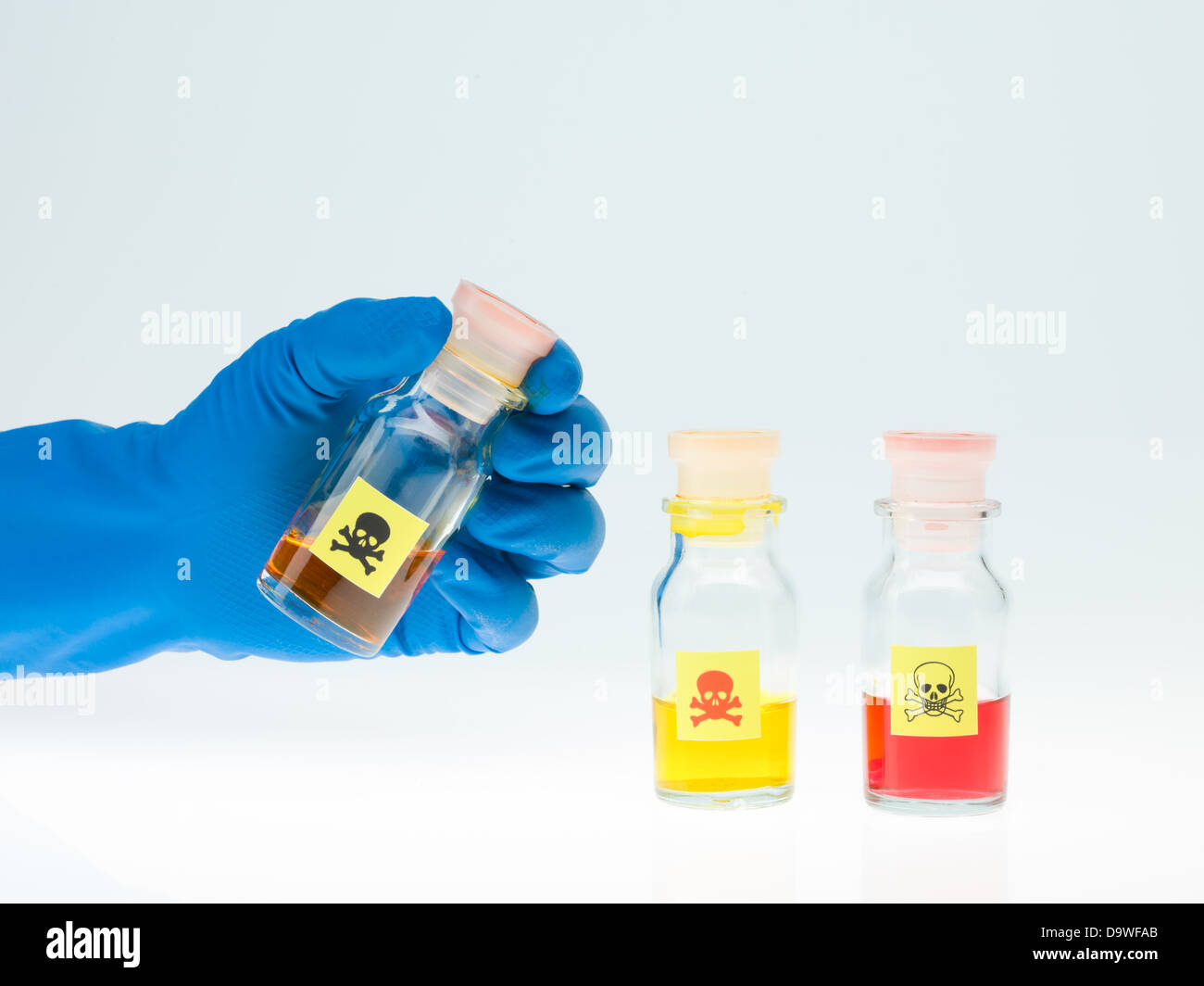 frontal view of three transparent colorless bottles filled with colored ...