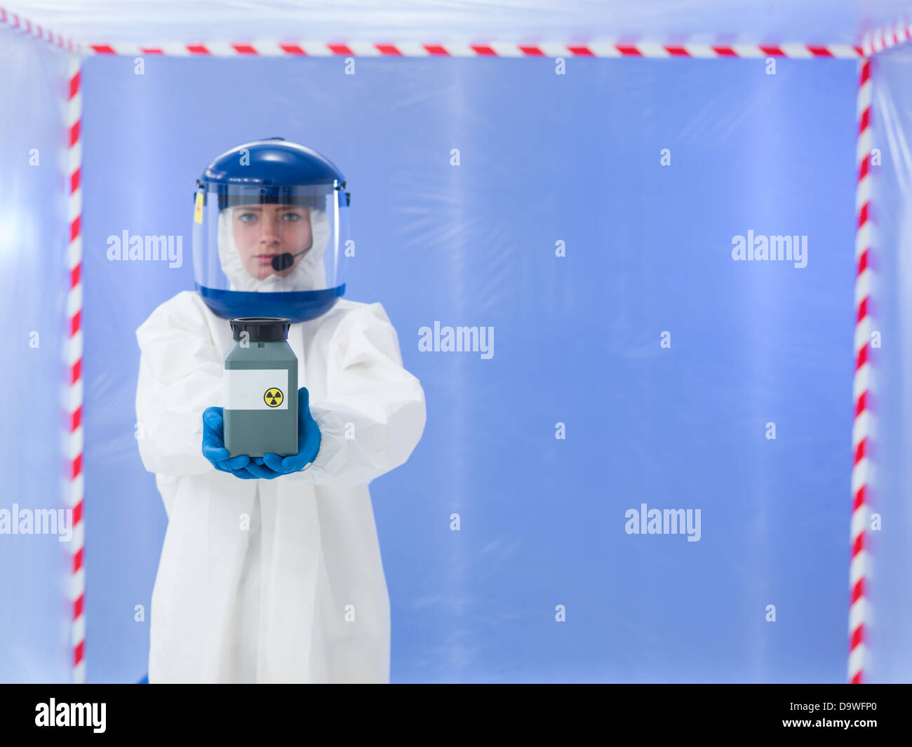 female scientist wearing white protection suit and blue mask, holding a ...