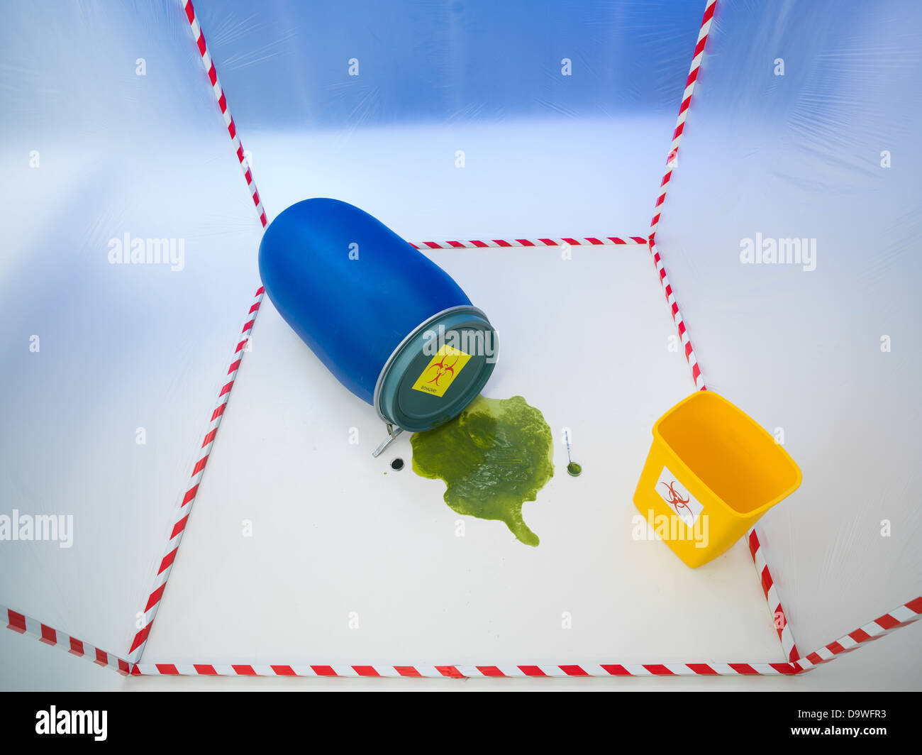 upper view of toxic waste spilling from a blue barrel in a white cube ...