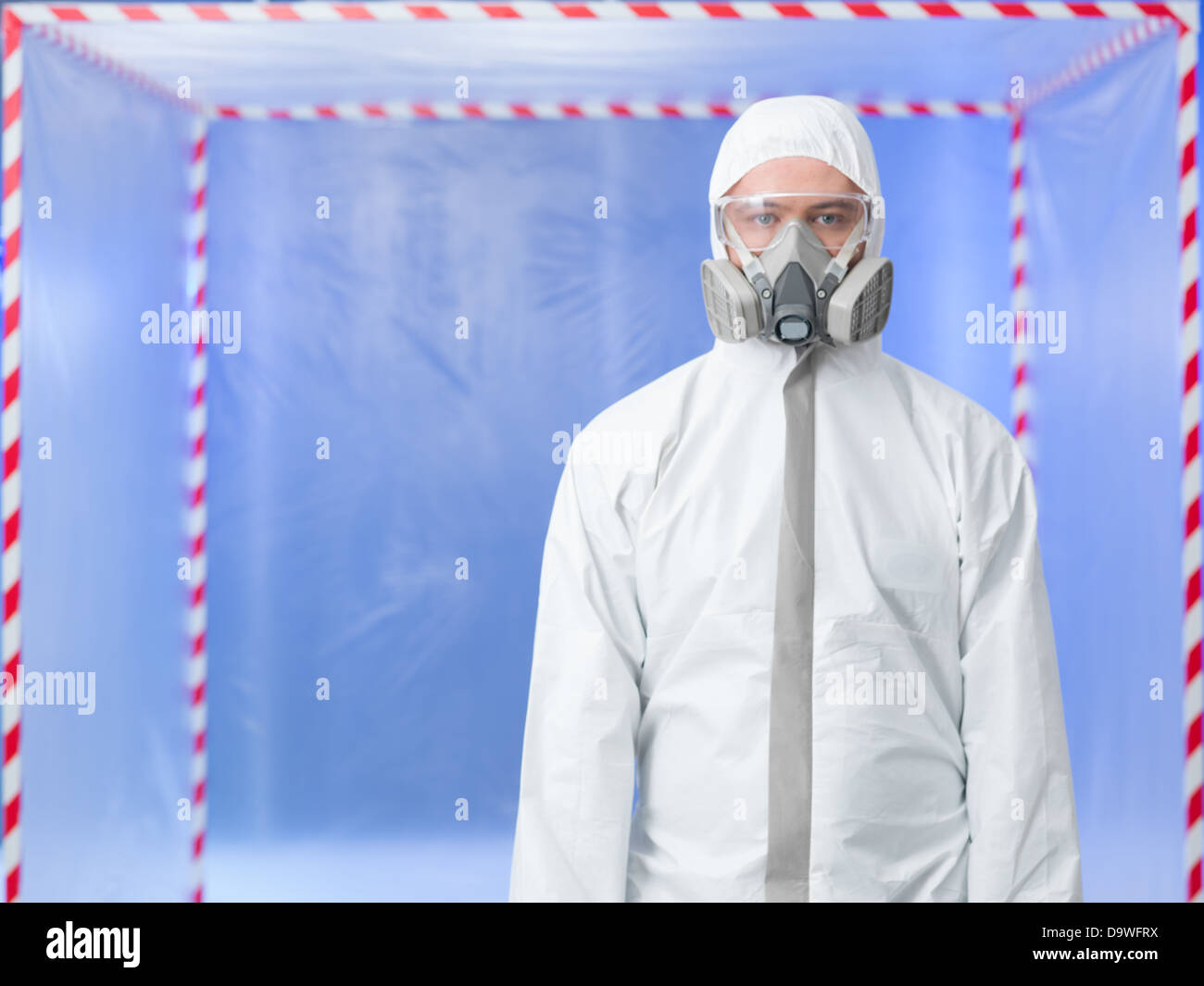 male researcher wearing protection equipment, standing in a chamber ...