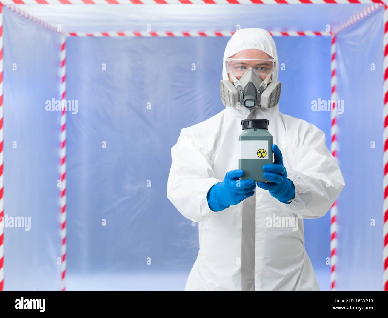 male scientist wearing protection equipment holding a toxic waste ...