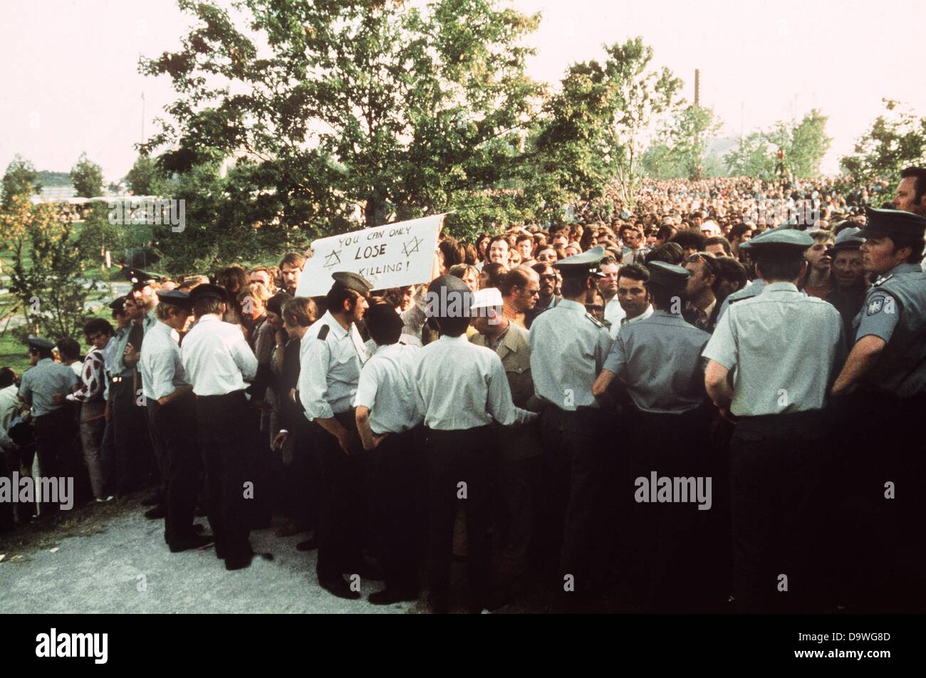 A queue of police forces keep a crowd of bystanders covered in front of ...