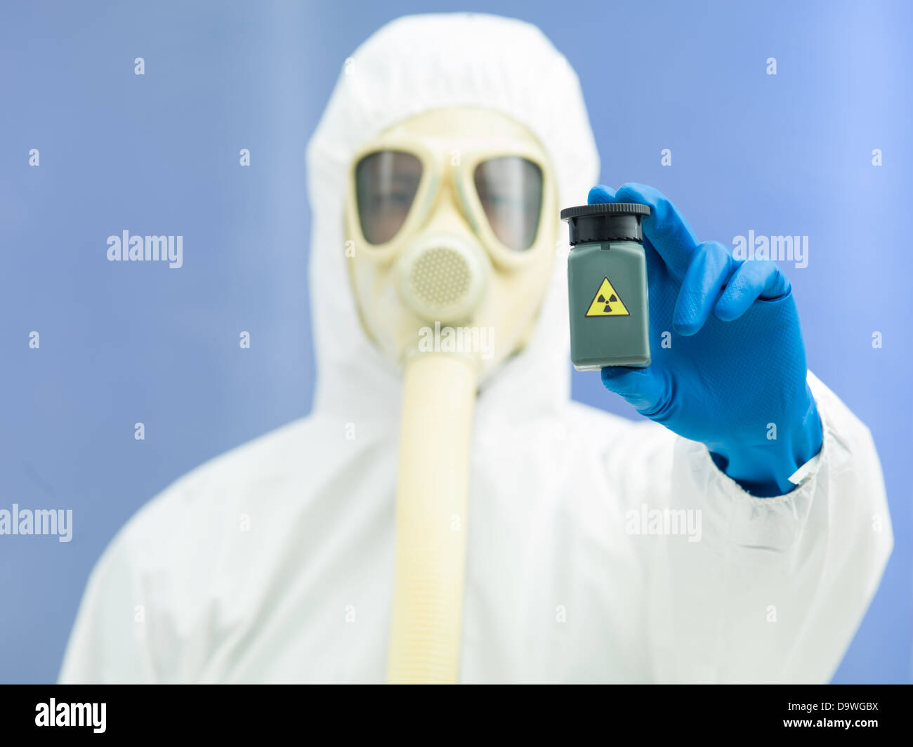 person in bio hazard suit and gas mask holding a radioactive isotope ...