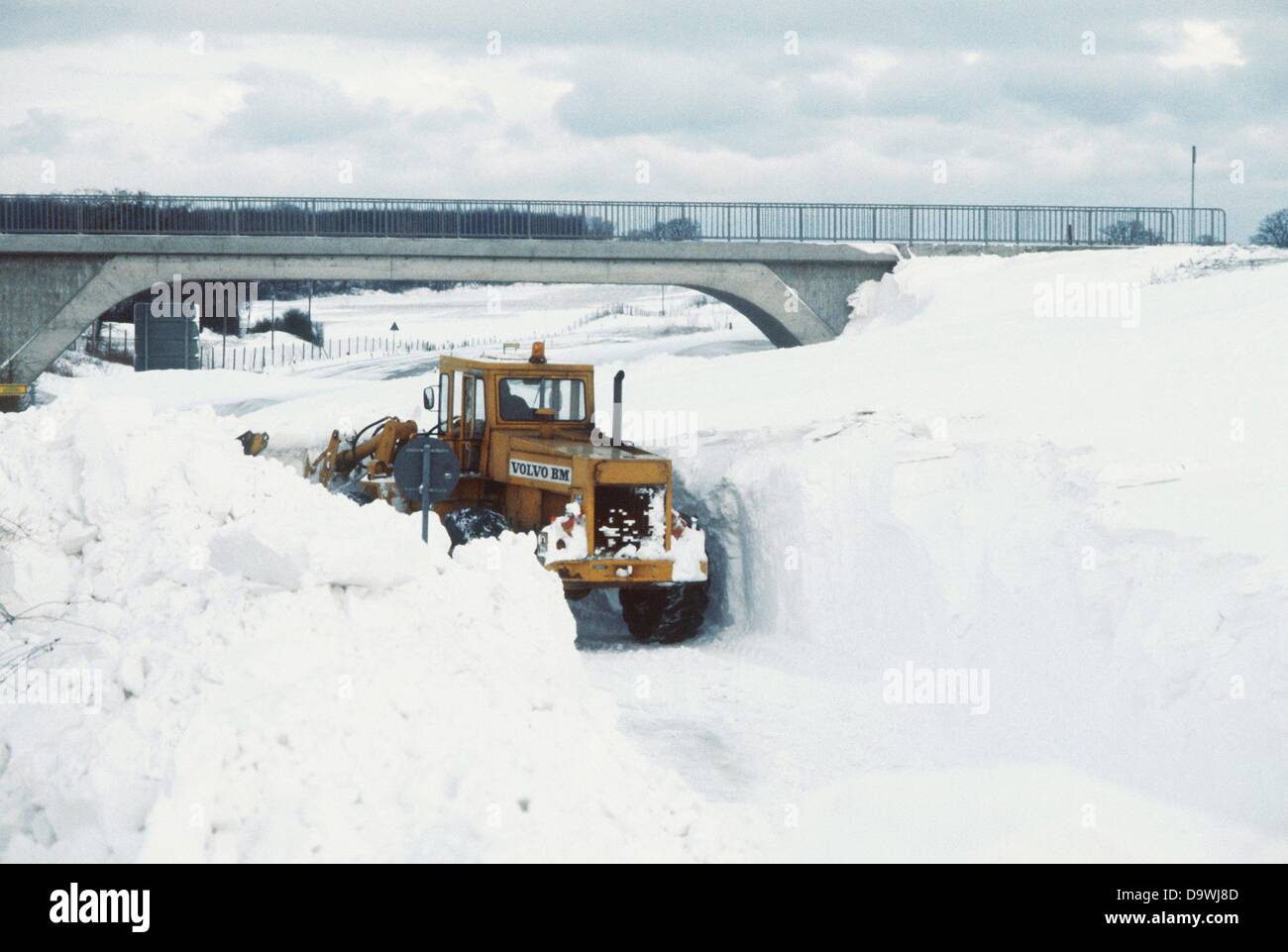 A snow-clearing vehicle channels its way through masses of snow ...