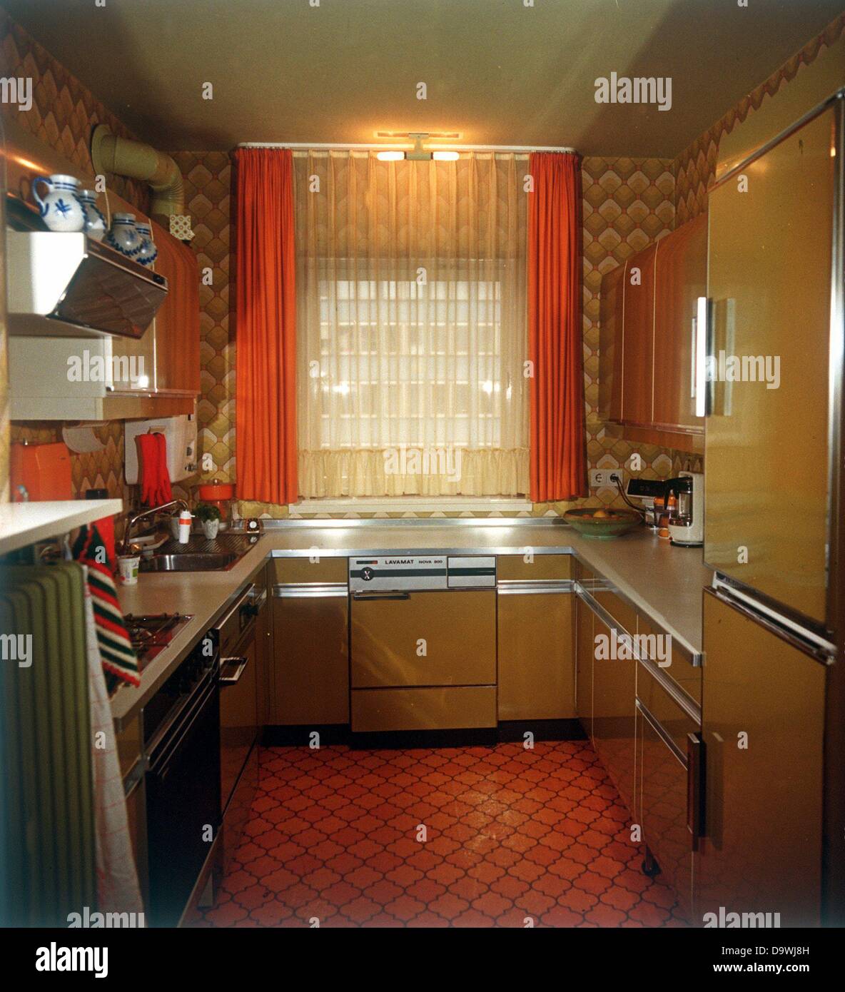View into a modern fitted kitchen in orange and beige from the 1970s ...