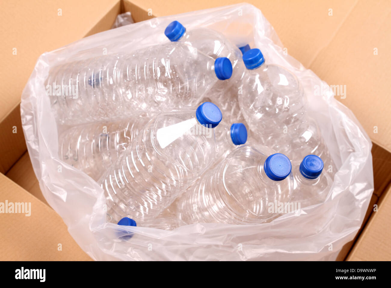 Rubbish bag with bottles of water for recycling inside a cardboard box ...