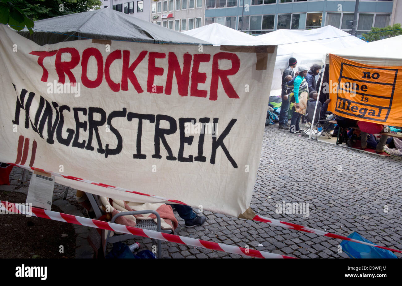 A mother and her child sit next to a banner saying 'Dry Hunger Strike ...