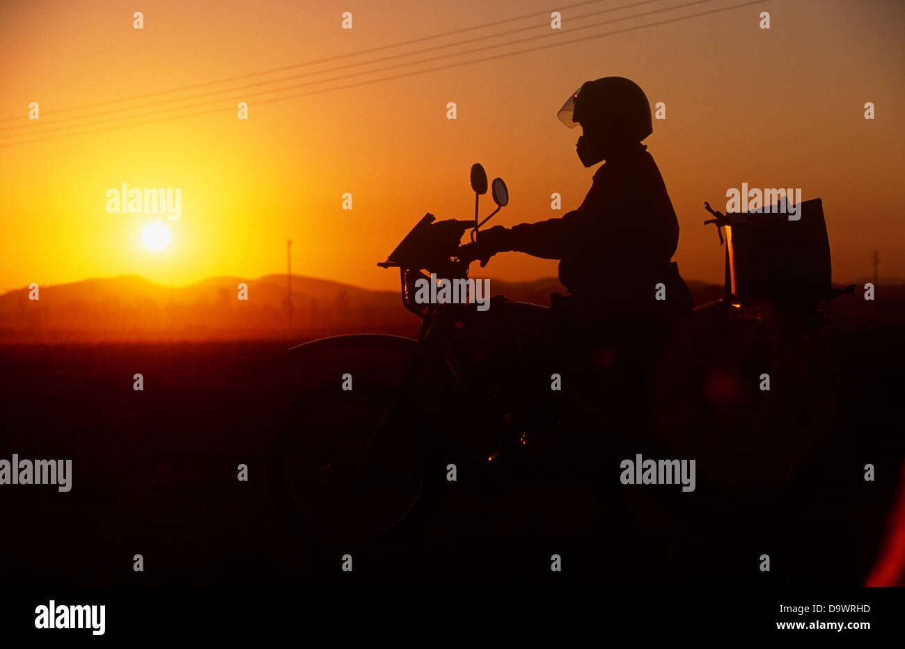 A motorcycle rider is photographed at sunset in Zimbabwe Stock Photo ...