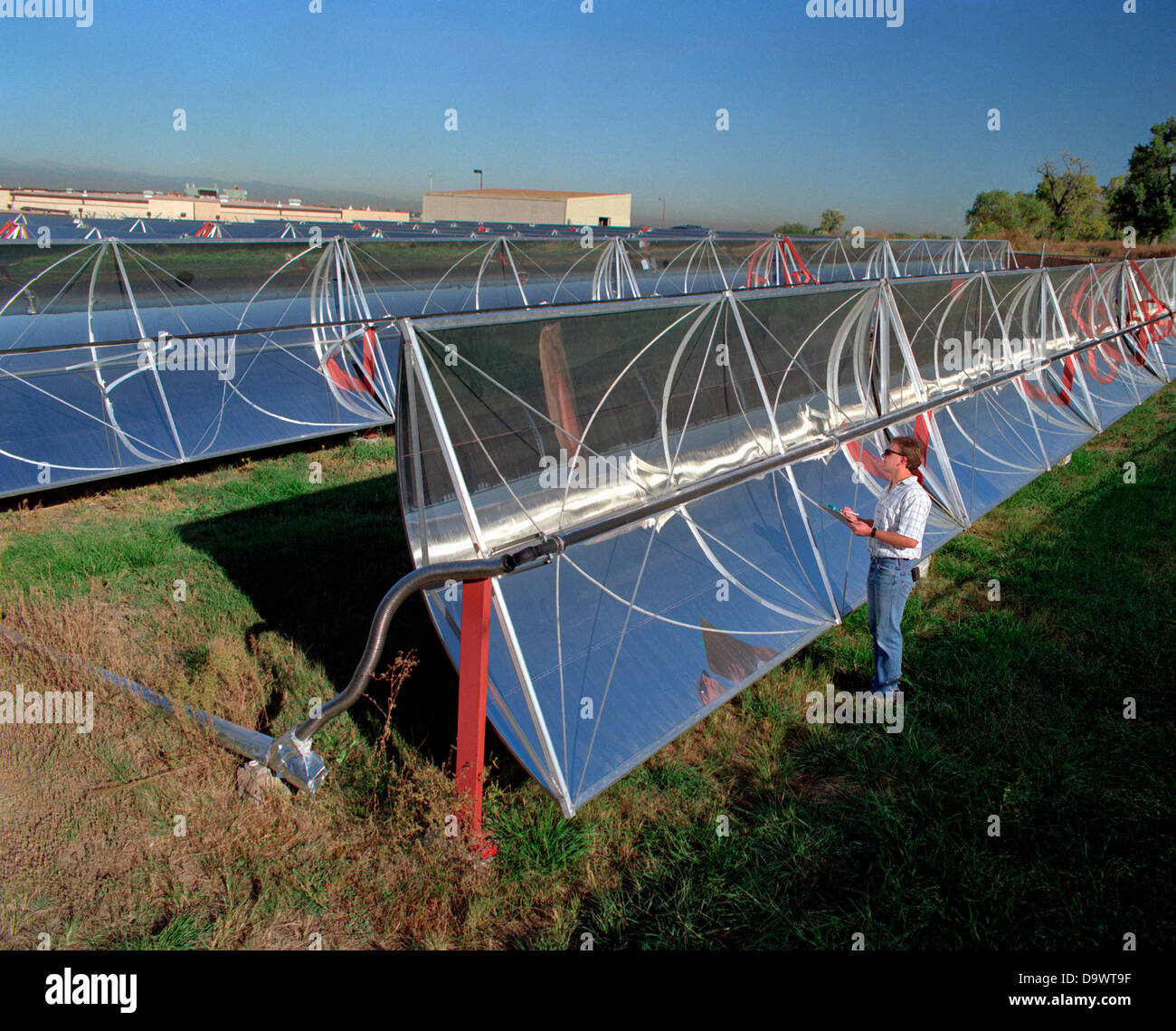 A technician works on the parabolic trough solar collectors by ...