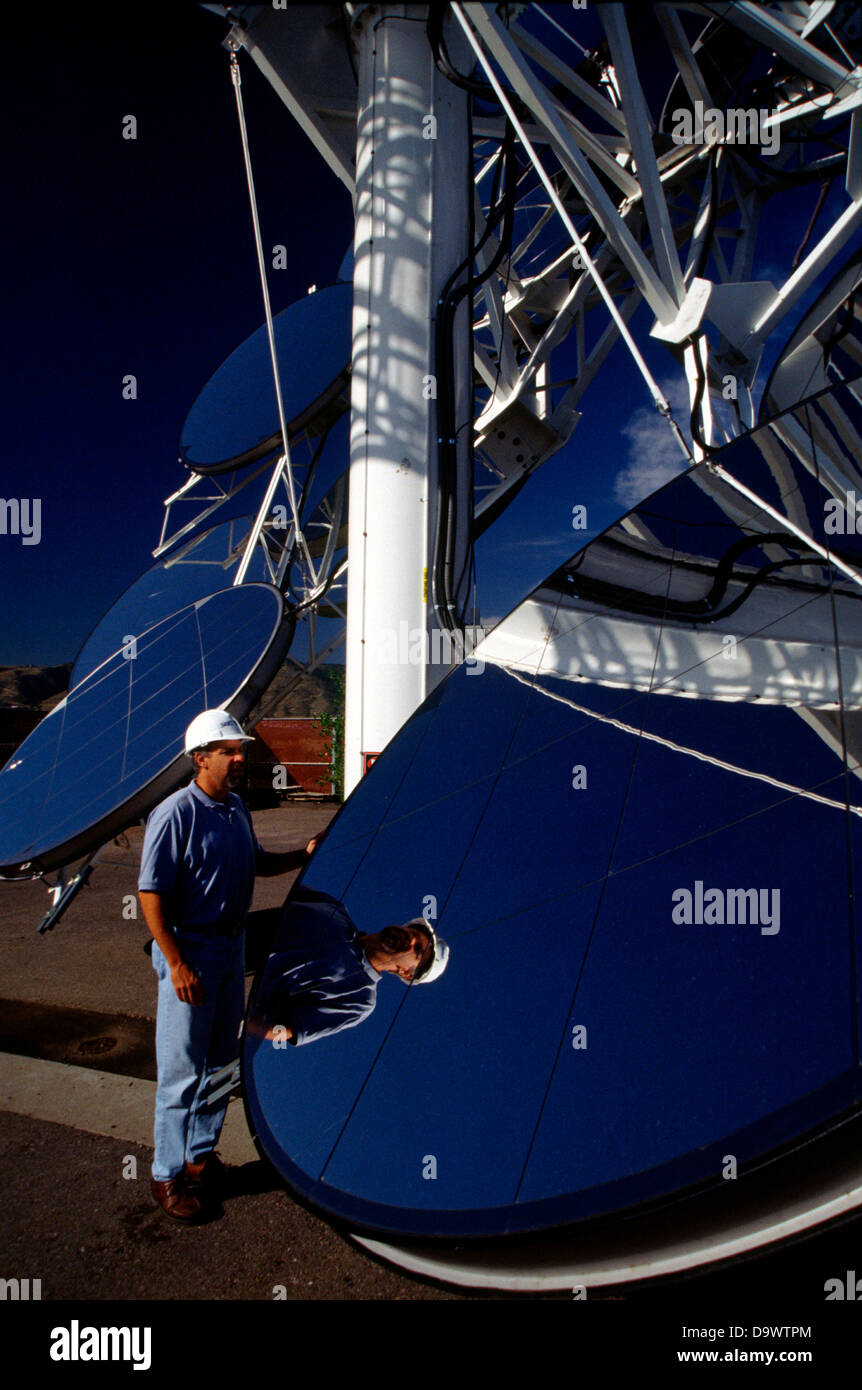 A technician works on a Stirling Solar power systems solar dish engine ...