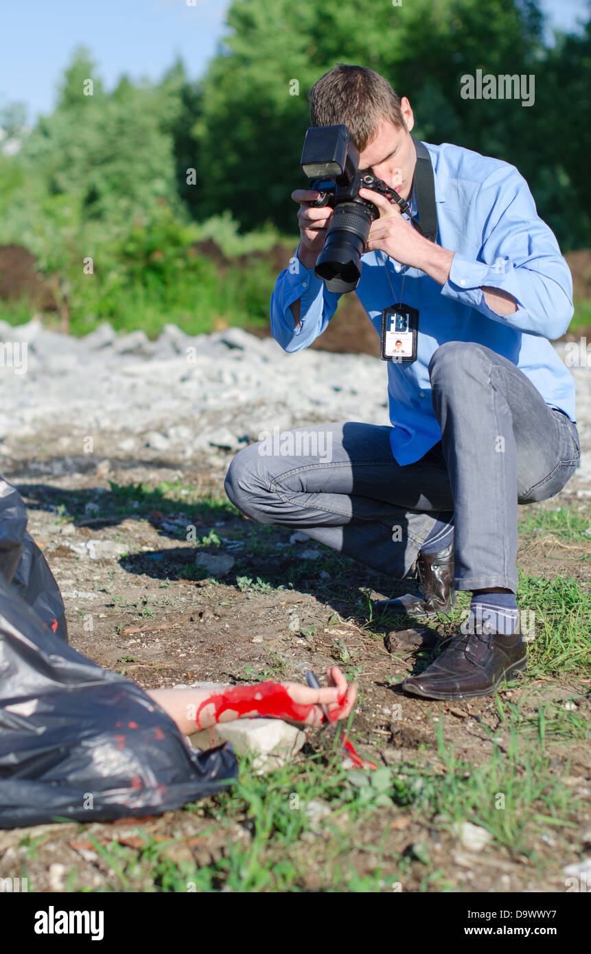 Young criminalist takes picture of crime scene Stock Photo - Alamy