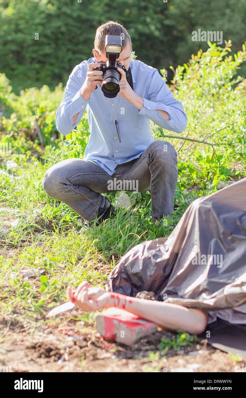 Young criminalist takes picture of crime scene Stock Photo - Alamy