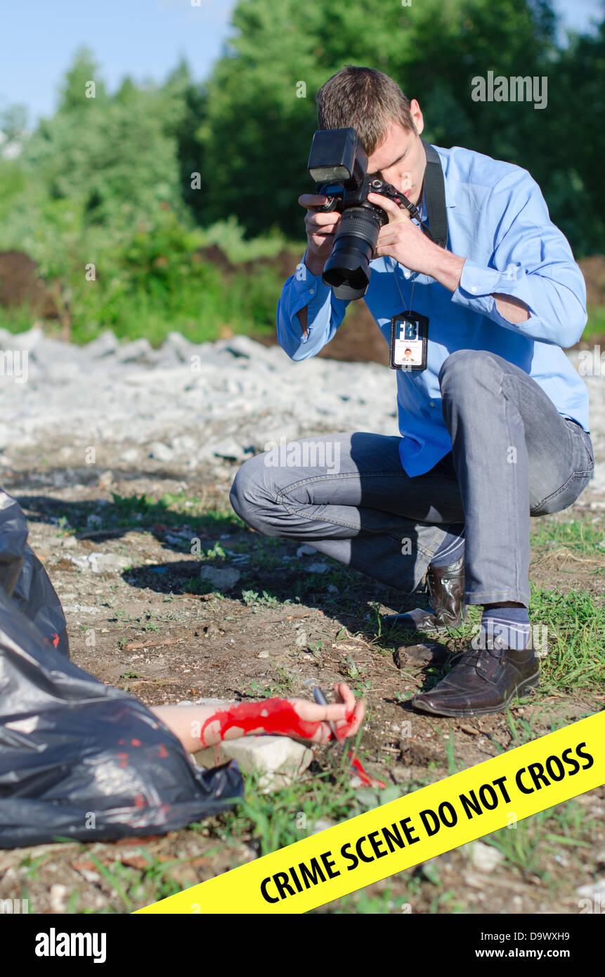 Young criminalist takes picture of crime scene Stock Photo - Alamy