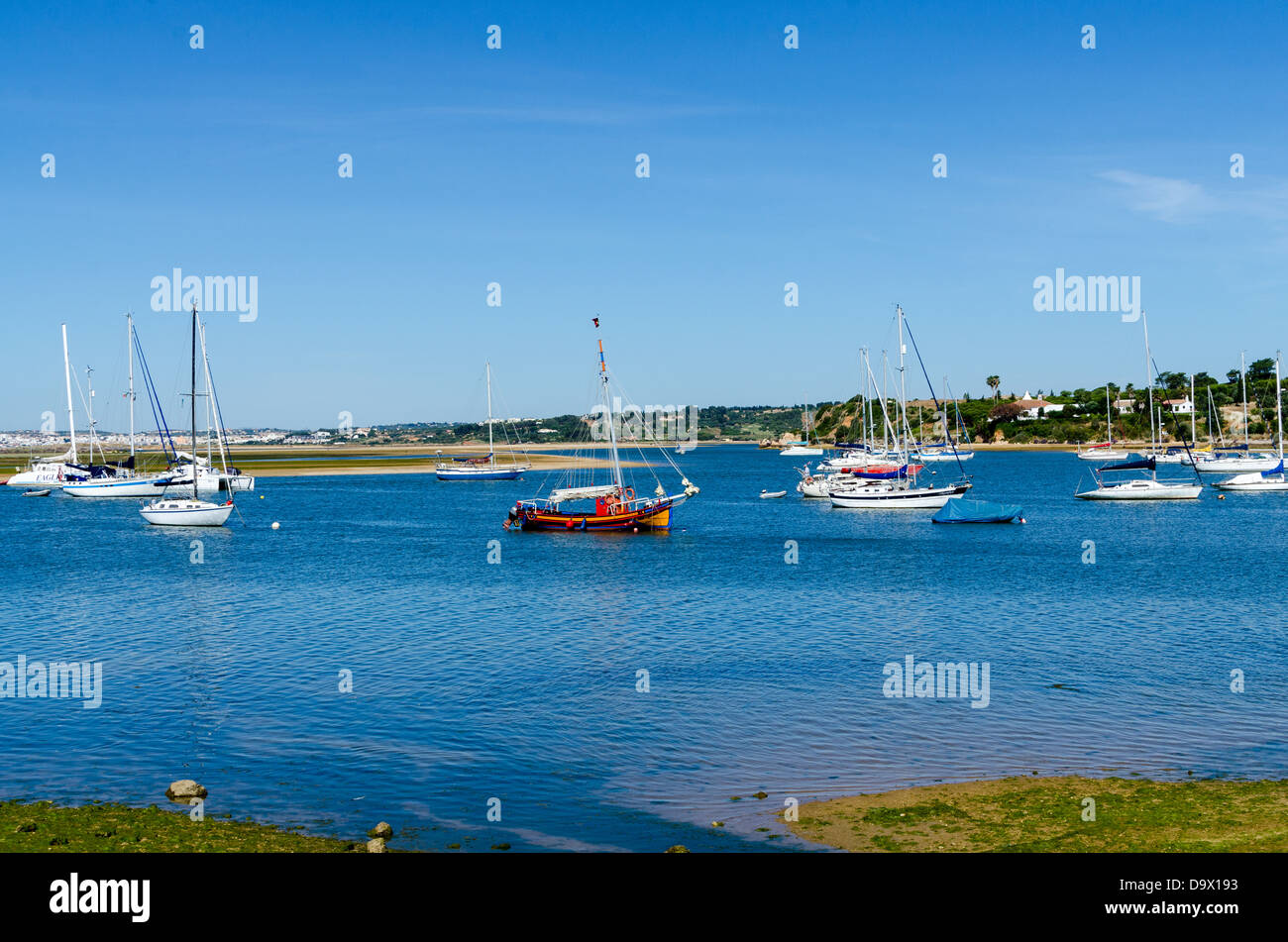 Boats moored in the estuary at the pretty town of Alvor in the Algarve ...