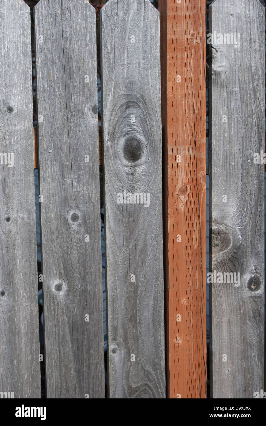 Weathered wooding fence, with a new fence post support Stock Photo - Alamy