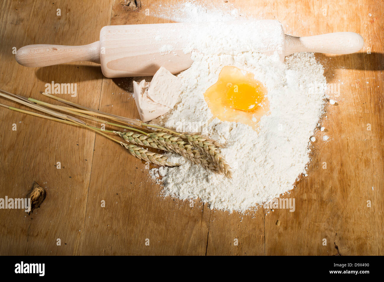 Pile of flour, rolling pin and wheat. Egg on flour Stock Photo - Alamy