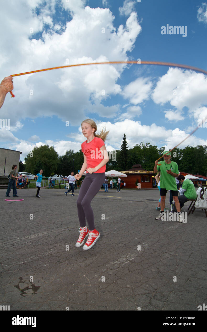 Girl jumping over a skipping rope Stock Photo - Alamy