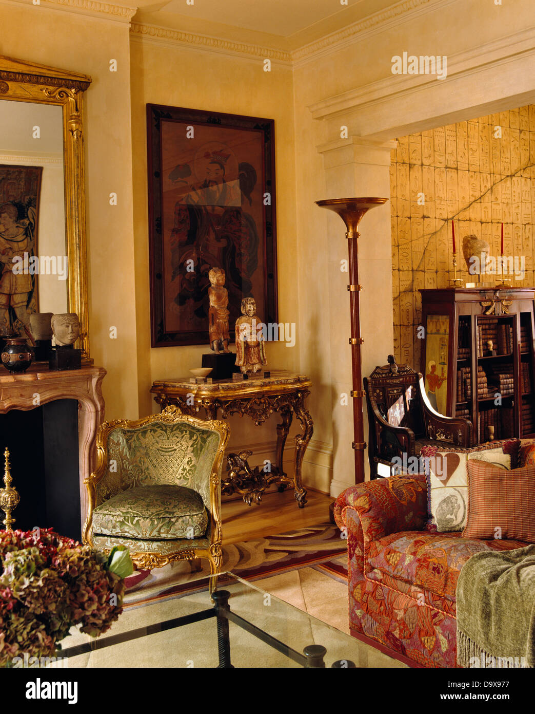 Upholstered gilt chair next to fireplace in grand drawing room with ...