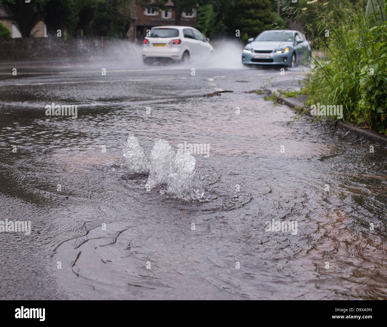 cars driving through flooded road caused by burst water main Stock ...