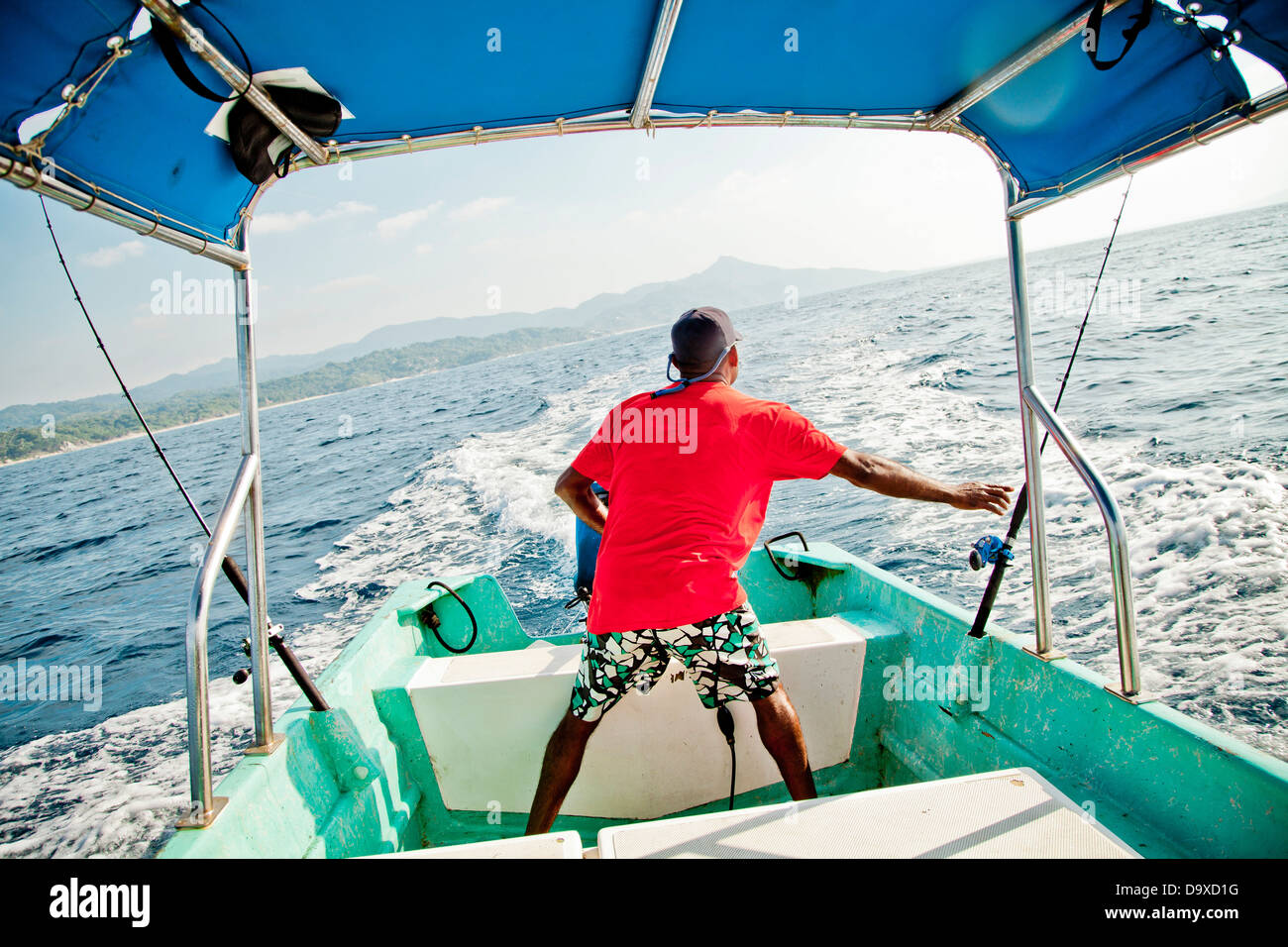 Man running fishing charter boat Stock Photo - Alamy