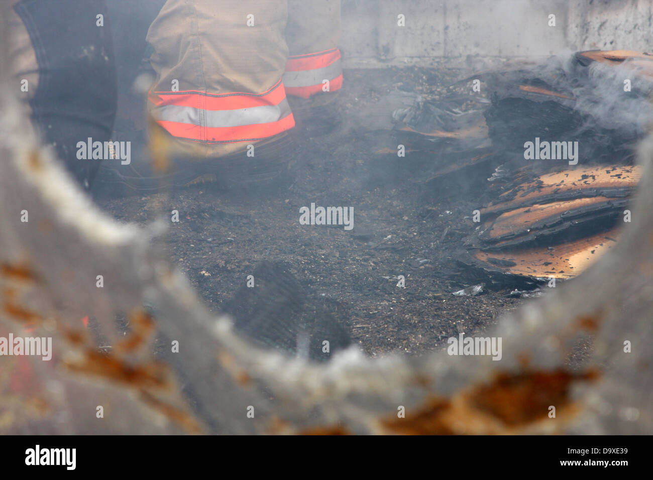 Firefighters at a fire scene inside a melted greenhouse building with ...