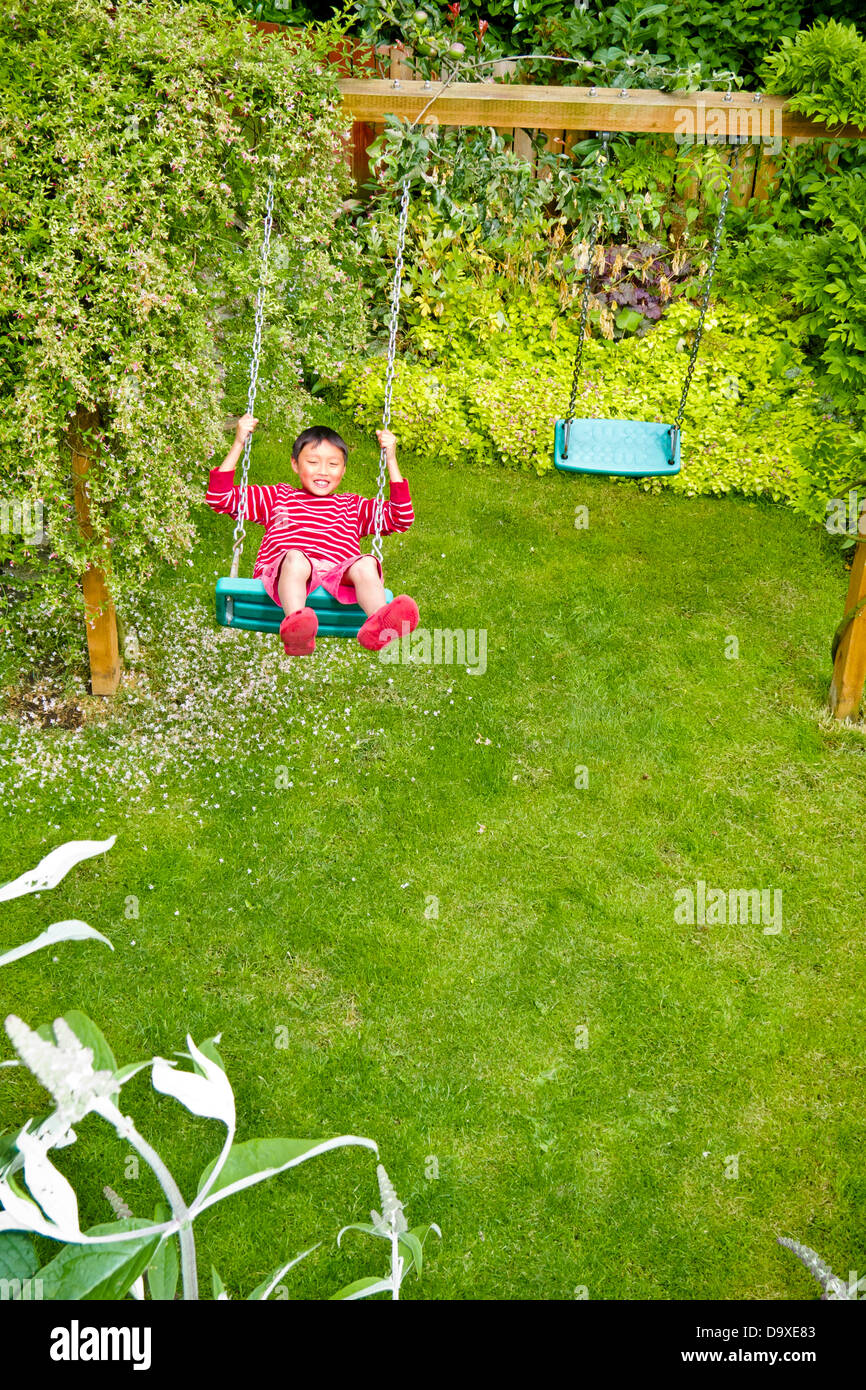 Boy on backyard swing Stock Photo - Alamy