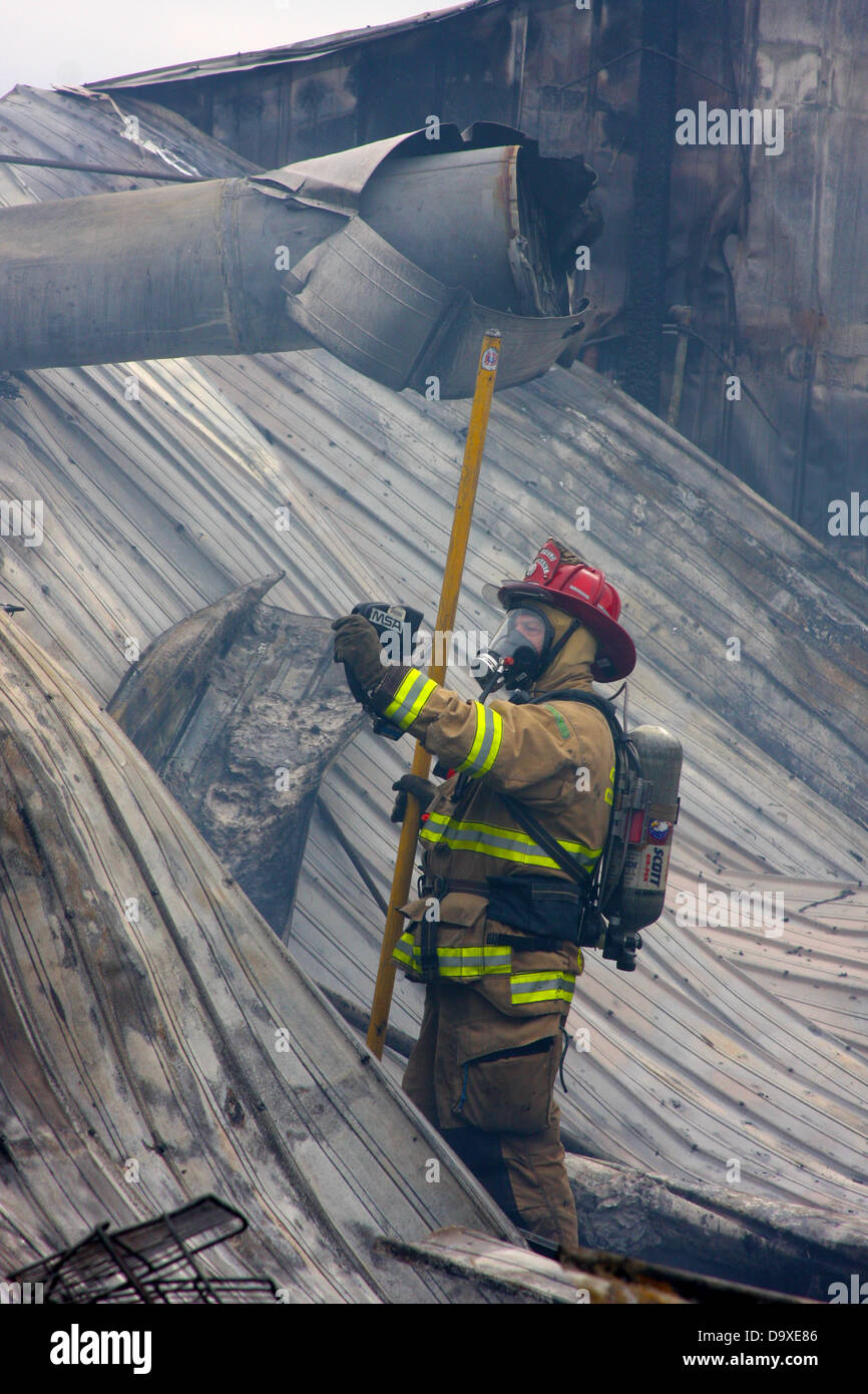 A firefighter using equipment to find hot spots Stock Photo - Alamy
