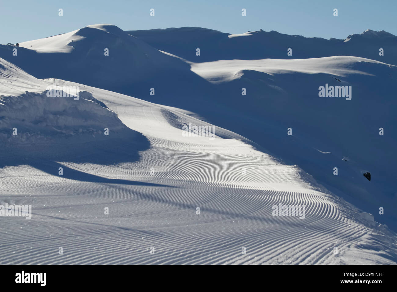 Snow covered mountains with a slope in the foreground Stock Photo - Alamy
