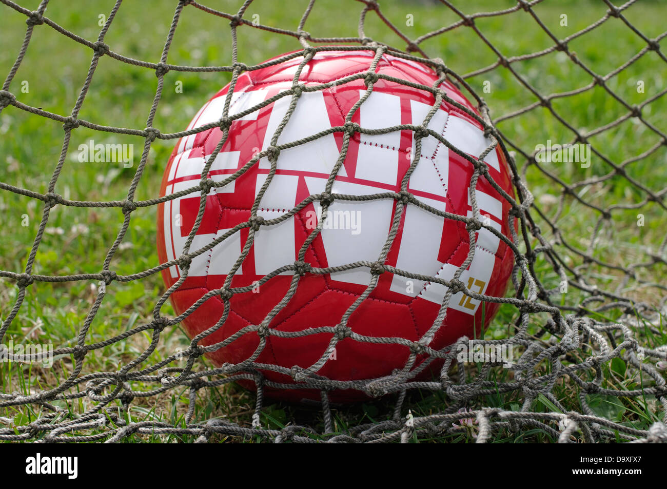 Red football with white text eng in goal net Stock Photo - Alamy