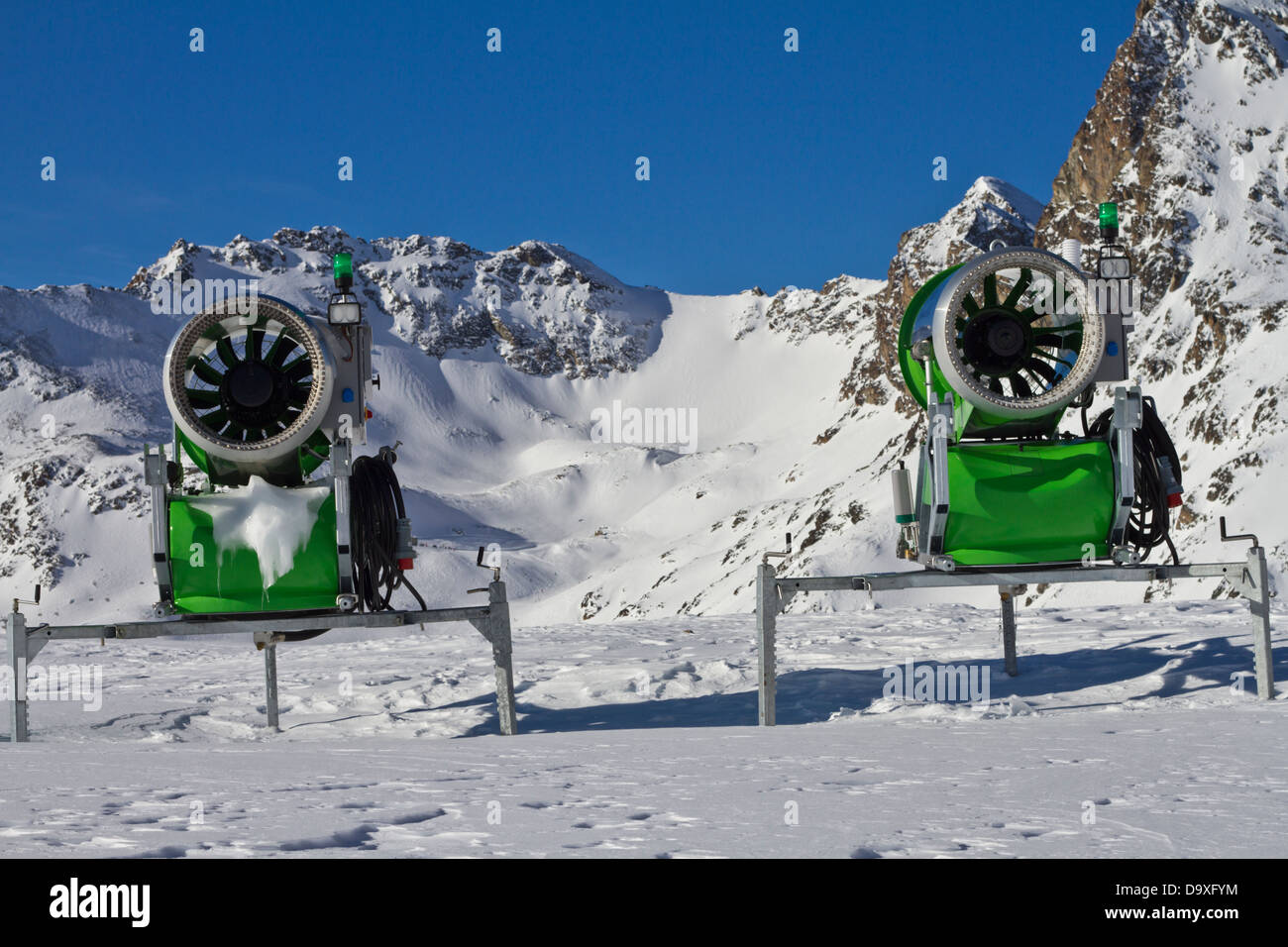 Two idle snow cannons in front of mountains and blue sky Stock Photo ...