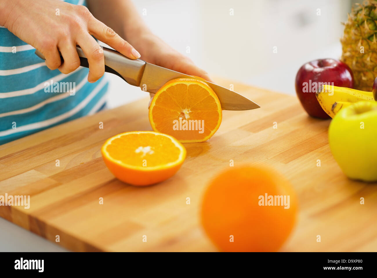 Closeup on woman cutting orange Stock Photo - Alamy