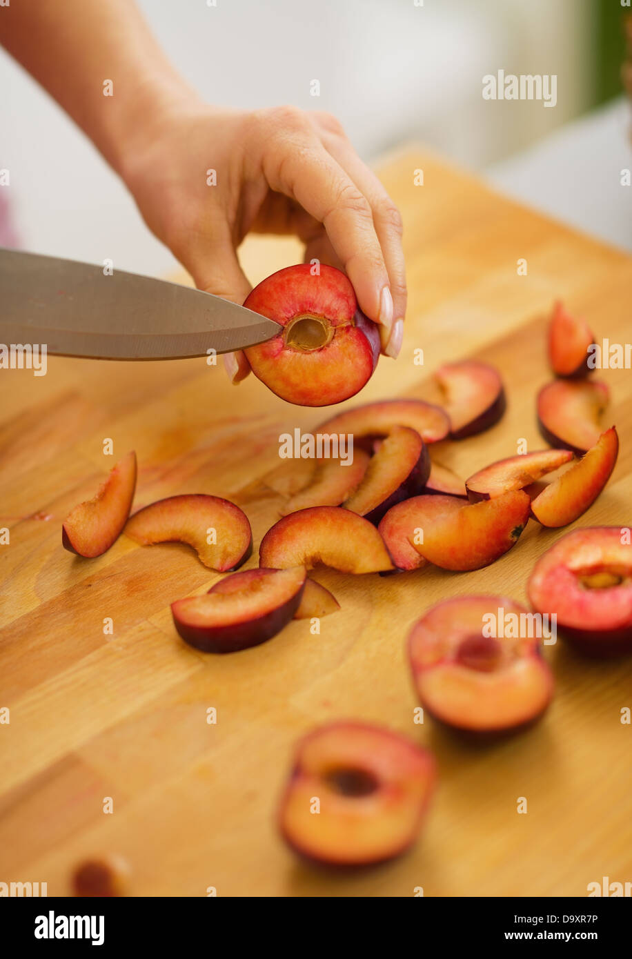 Closeup on young housewife cutting plums Stock Photo - Alamy