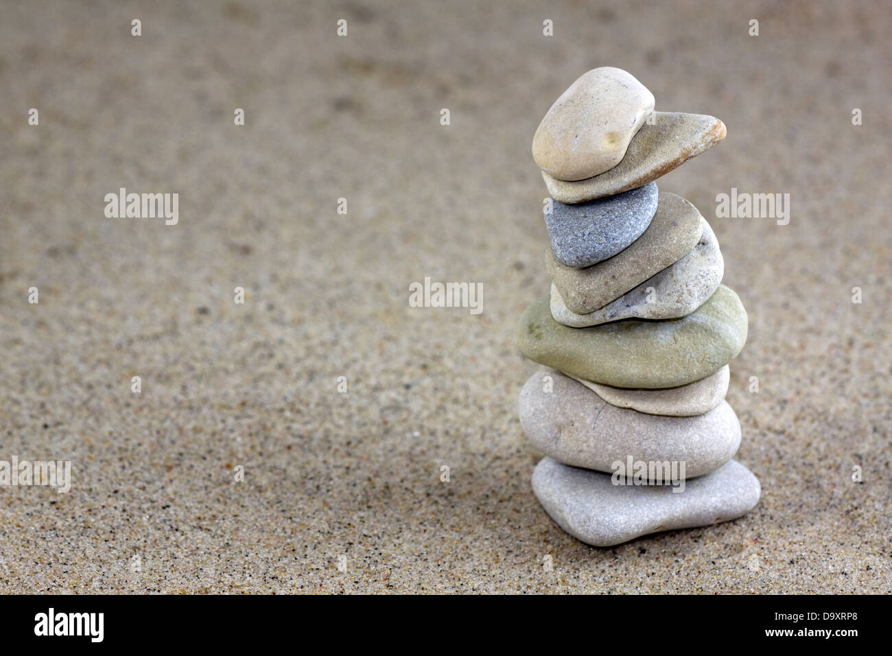 Balancing pebbles placed on sand Stock Photo - Alamy