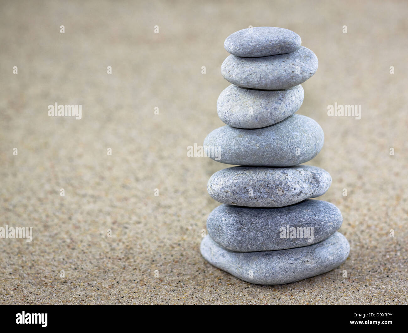 Balancing pebbles placed on sand Stock Photo - Alamy