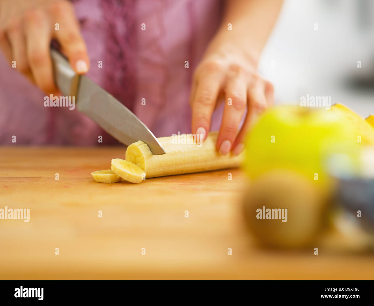 Closeup on woman cutting banana on cutting board Stock Photo - Alamy
