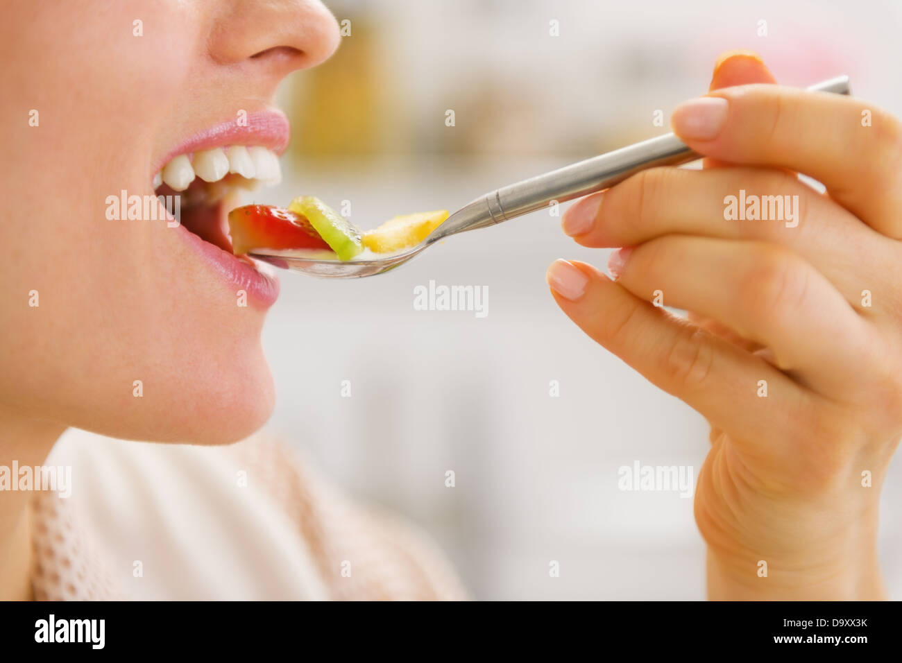Closeup on woman eating fruits on spoon Stock Photo - Alamy