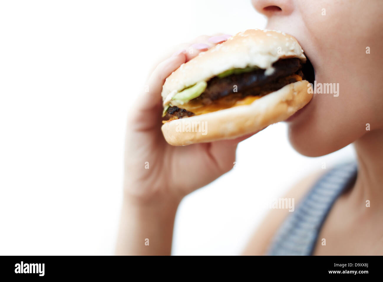 Woman eating hamburger. Side view Stock Photo - Alamy
