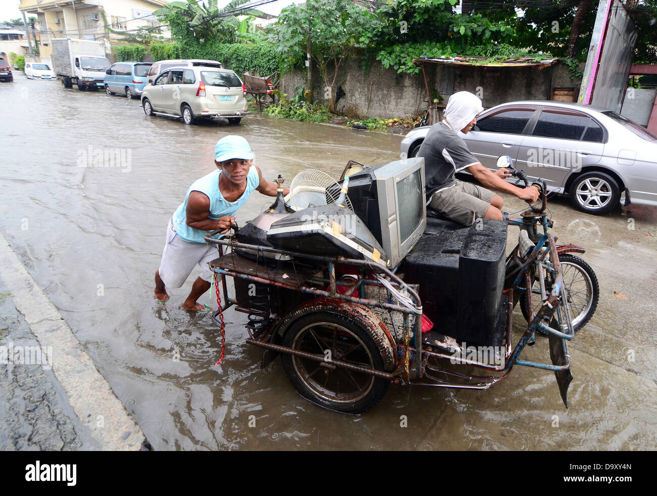 Davao, Philipinnes. 28th June 2013. Filipino residents carrying their ...