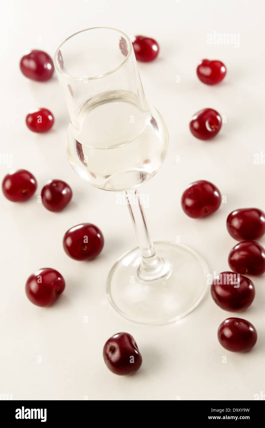 fruit brandy and some cherries in the background Stock Photo - Alamy